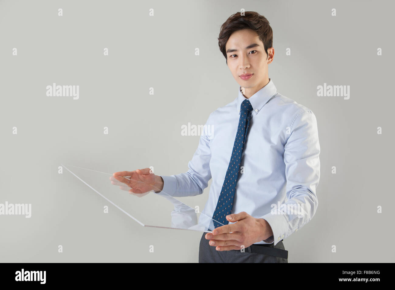 Businessman holding touch screen and staring forward Stock Photo - Alamy