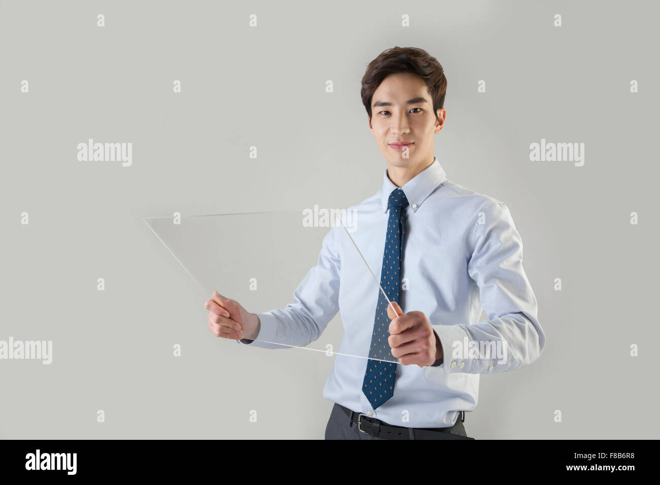 Businessman holding touch screen and staring forward Stock Photo - Alamy