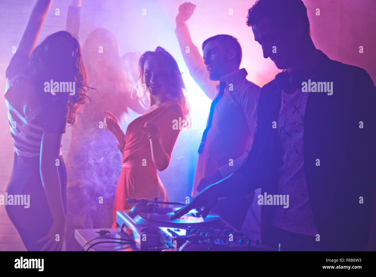 Male deejay and dancing friends enjoying night party Stock Photo - Alamy