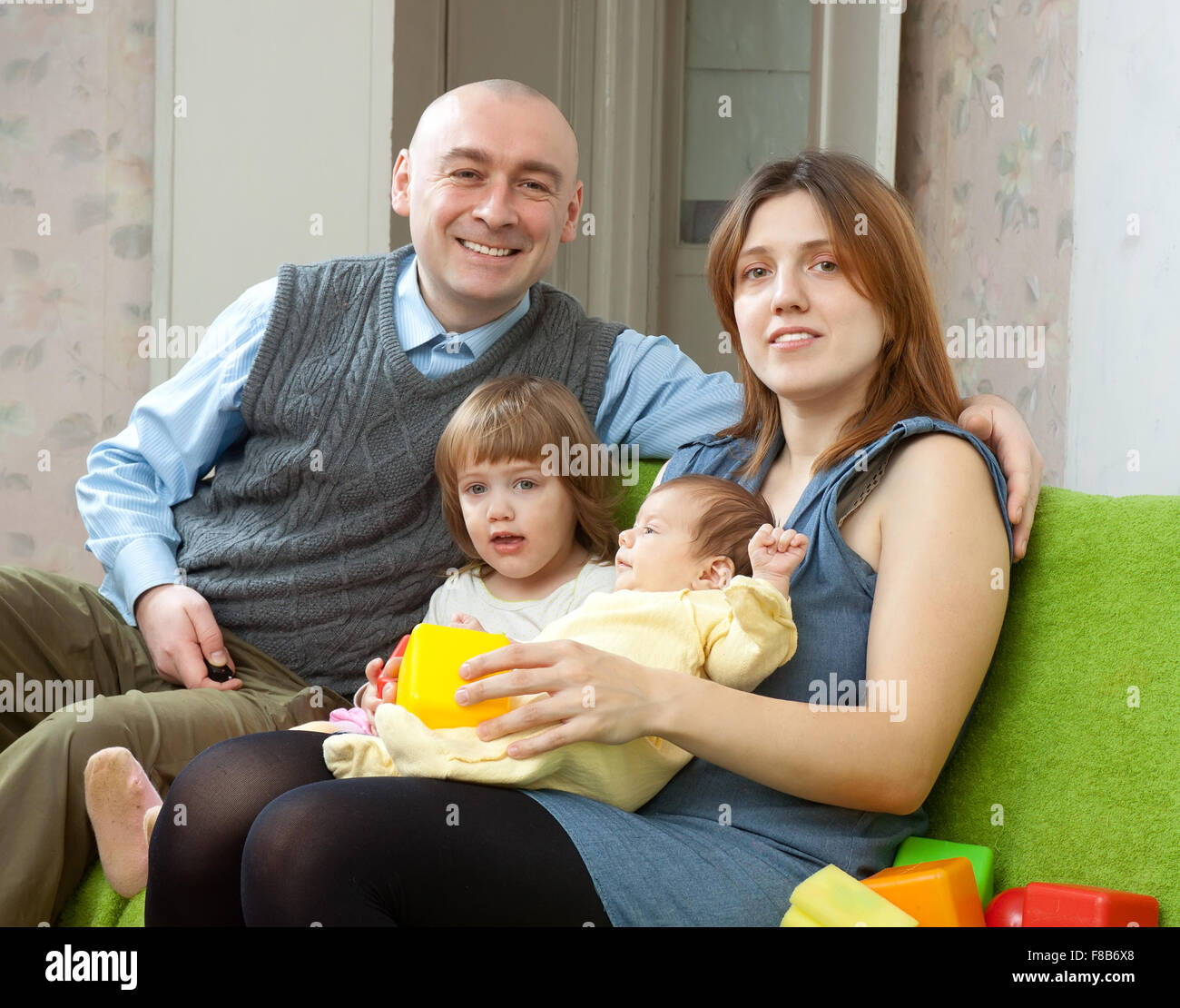 Happy family of four with newborn baby Stock Photo - Alamy