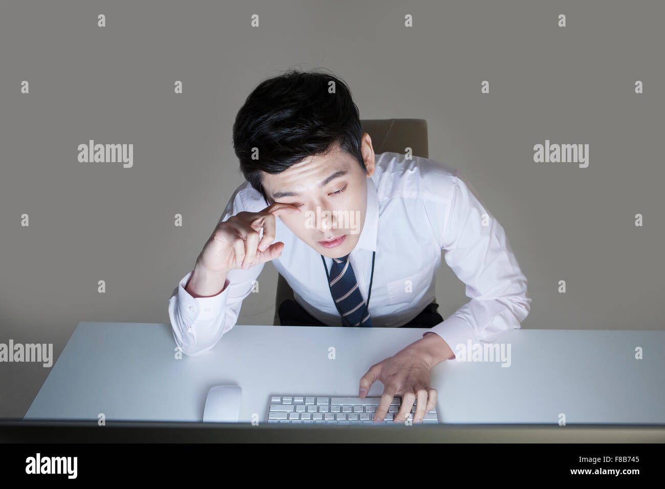 High angle of business man seated at desk working on computer with his ...