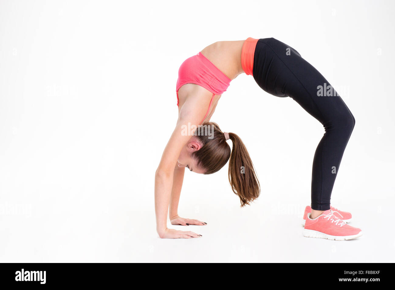 Beautiful young sportswoman doing back bend and stretching her back ...