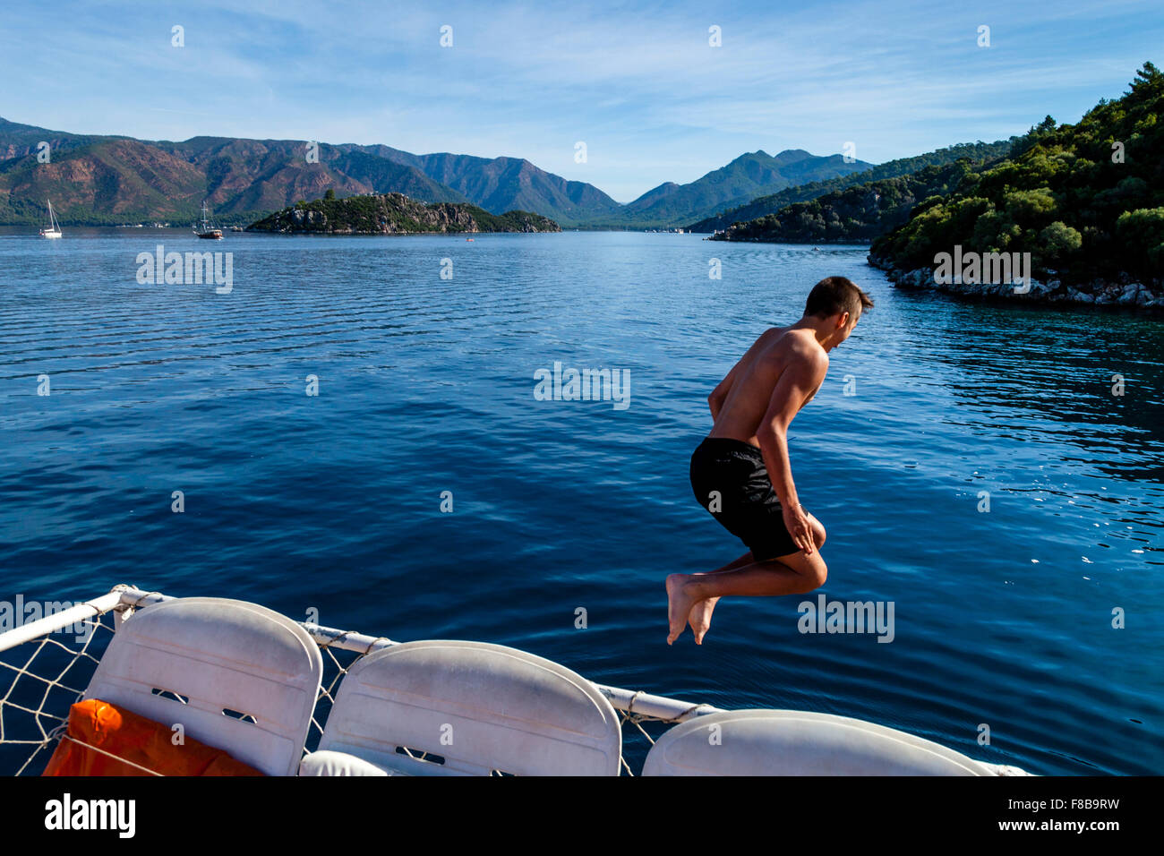 Boy jumping boat hi-res stock photography and images - Alamy