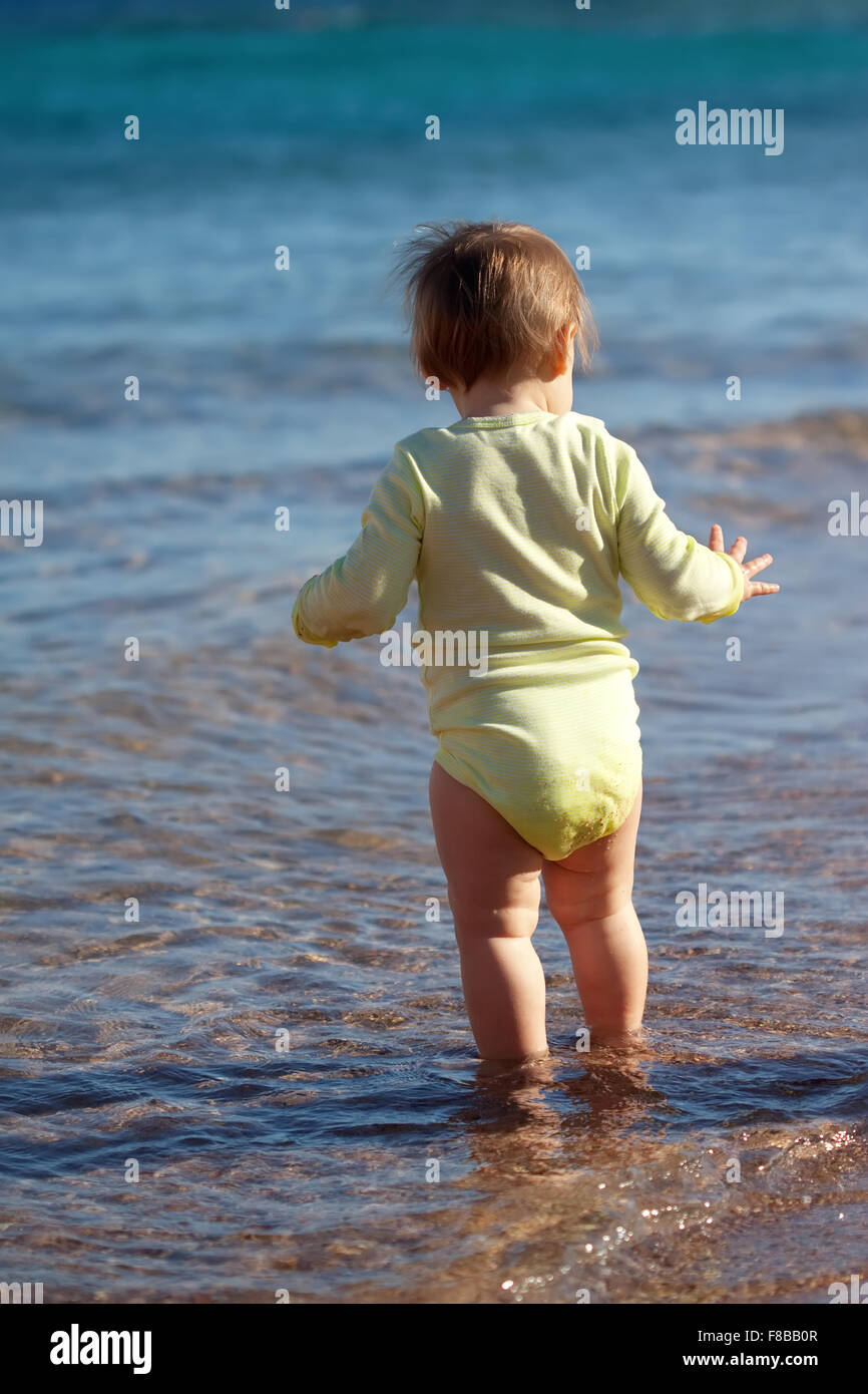 Rear view toddler in sea wave Stock Photo - Alamy
