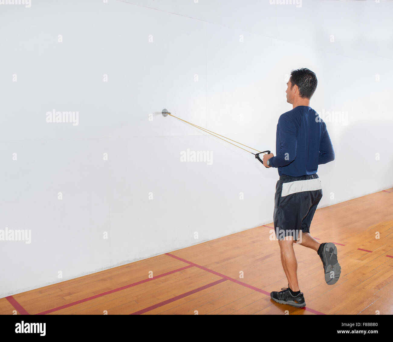 Middle age man showing resistance band exercise for lower lats and ...