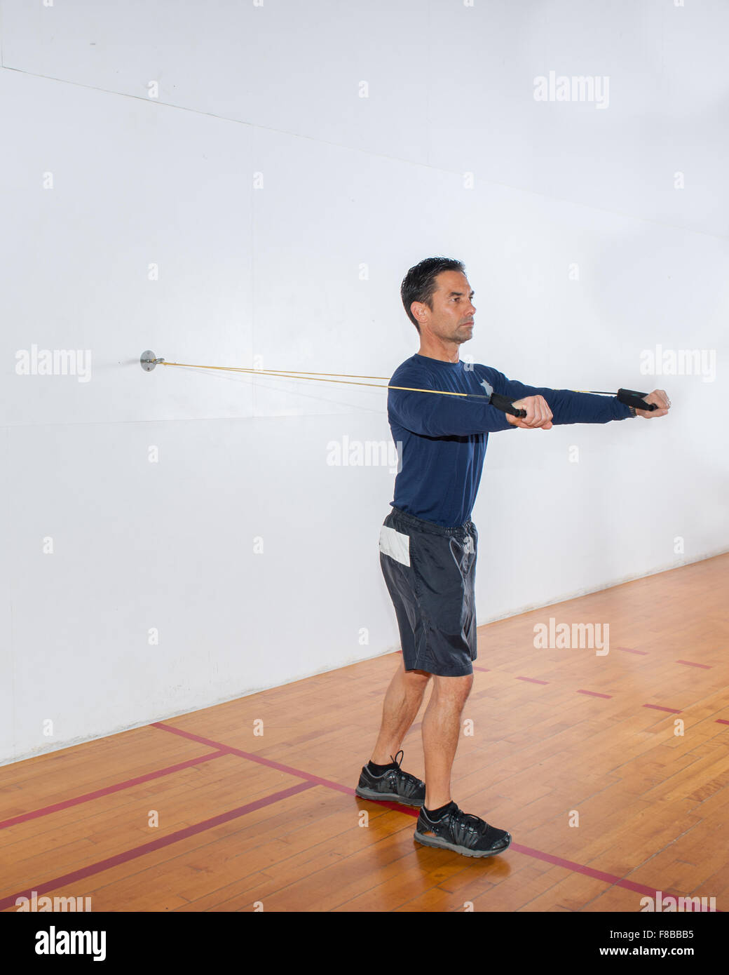 Middle age man showing resistance band exercise for the chest in finish ...