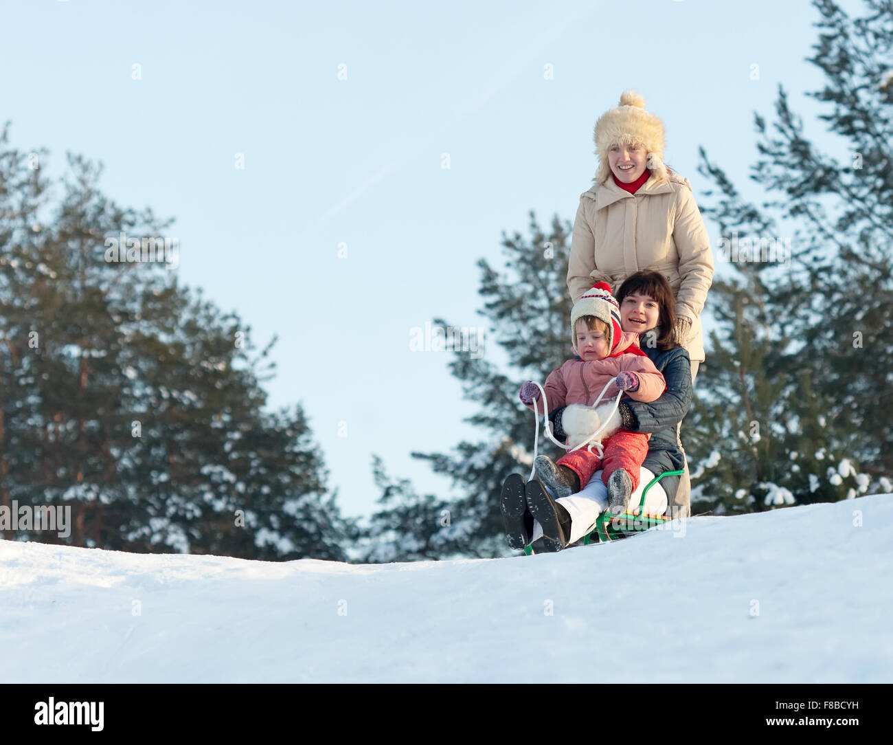 Women with child doing downhill on sleigh in winter park Stock Photo ...