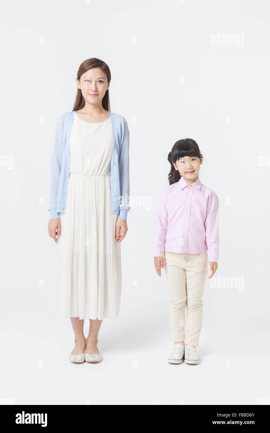 Mother and daughter standing next to each other and smiling Stock Photo ...