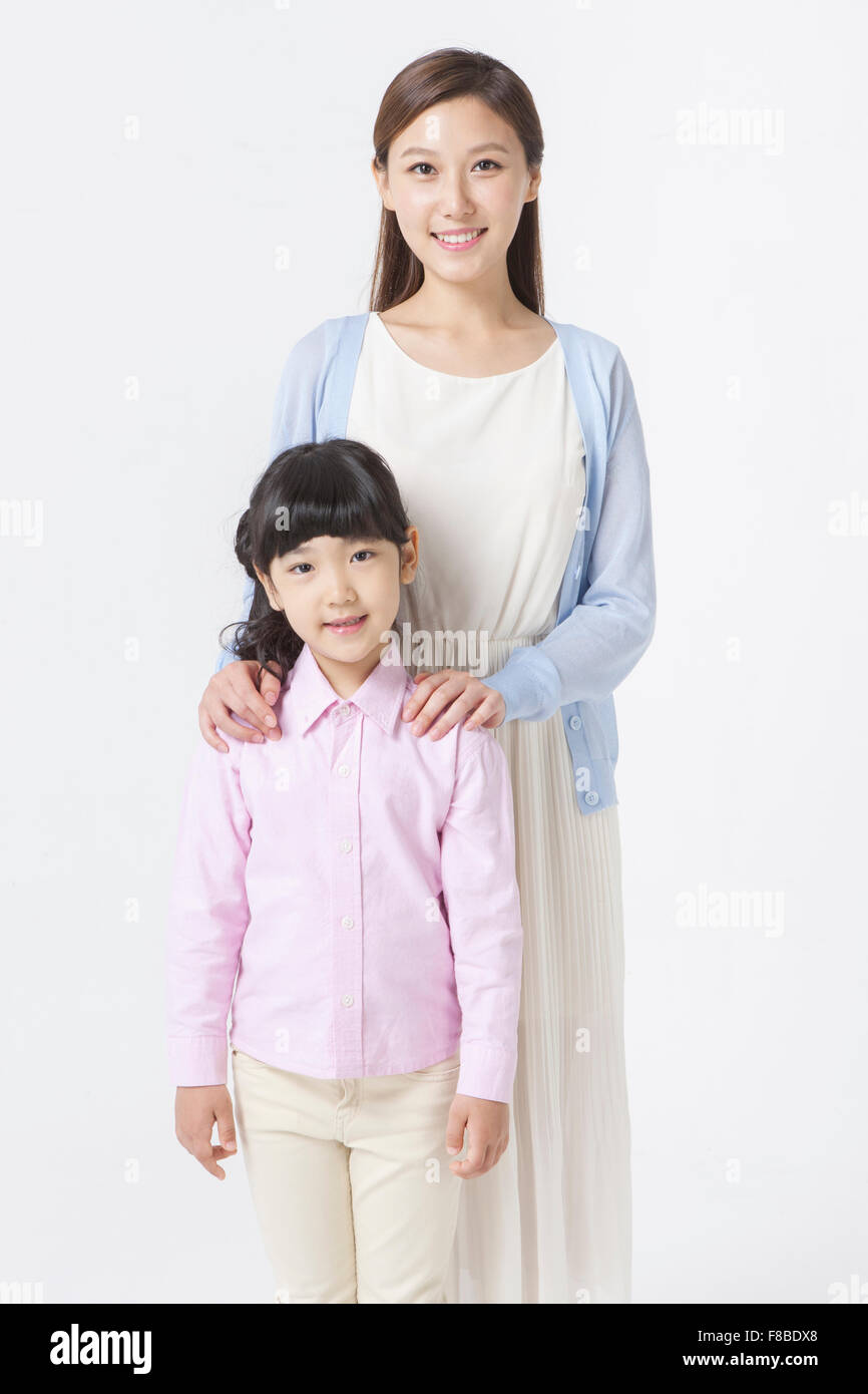 Mother Standing Behind Her Daughter With Her Hands On Daughters