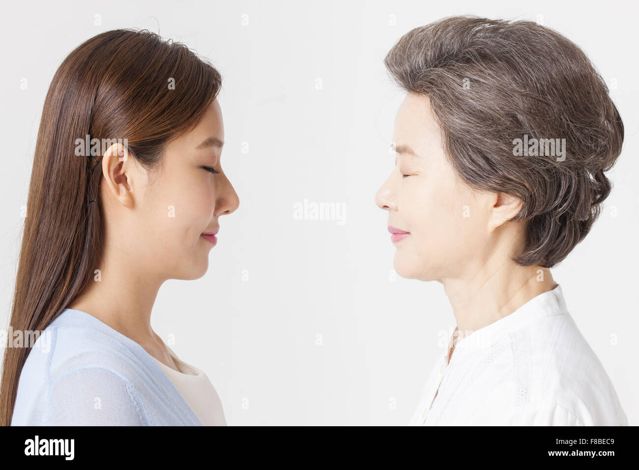 Mother and daughter facing each other with their eyes closed Stock ...