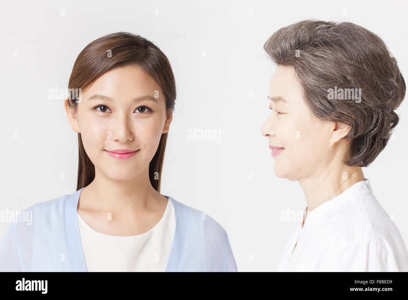 Daughter staring forward with a smile and mother looking at her ...