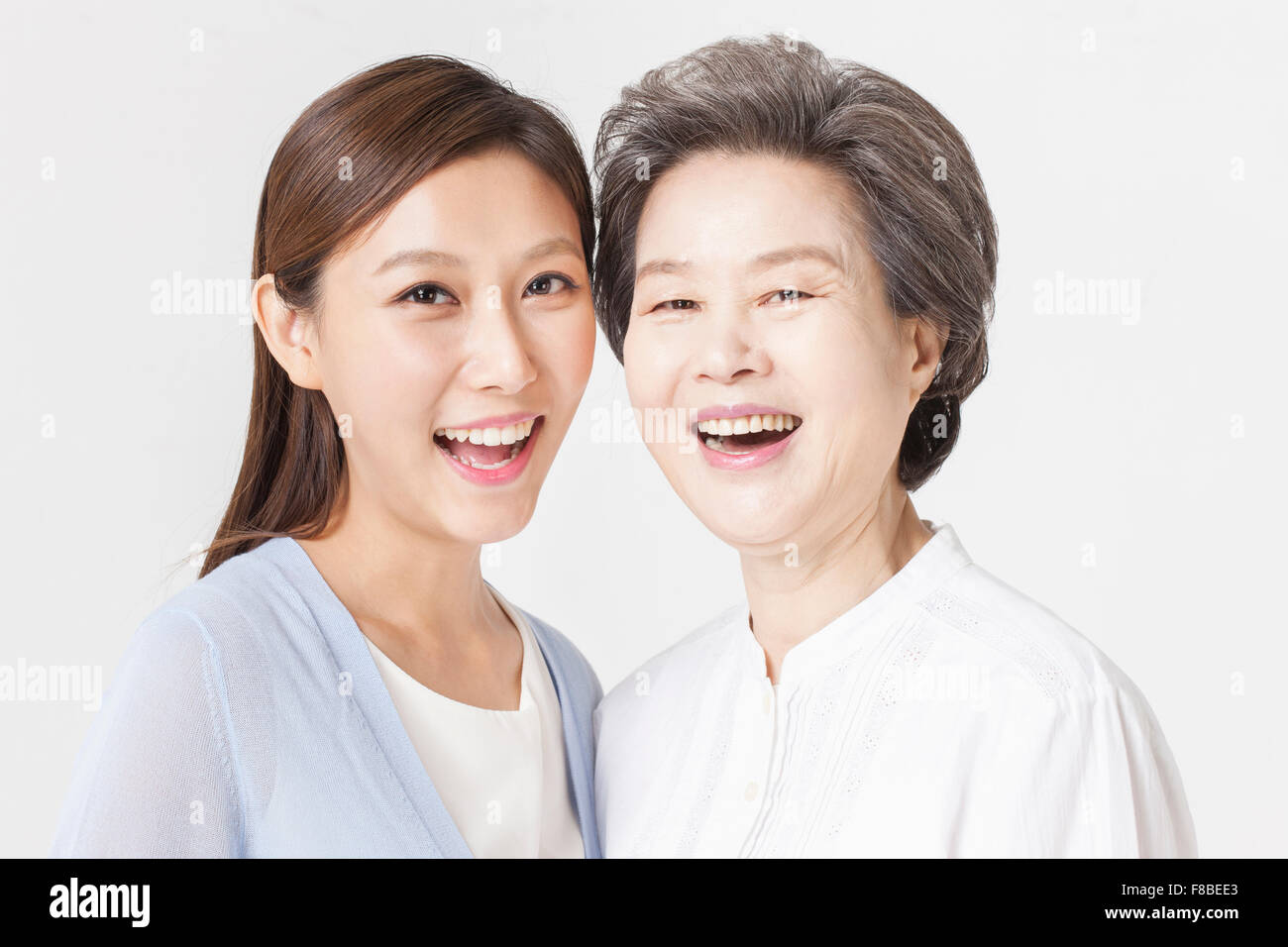 Mother and daughter staring forward with a smile Stock Photo - Alamy