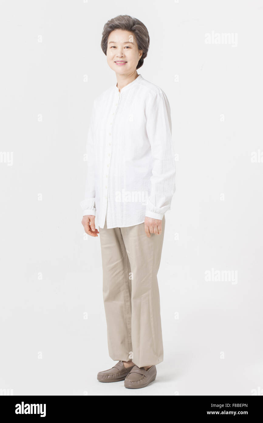 Grandmother with short hair in white shirt standing sideways and ...