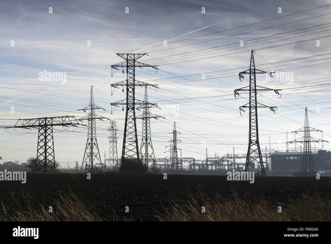 Electricity pylons with distribution power station blue cloudy sky ...