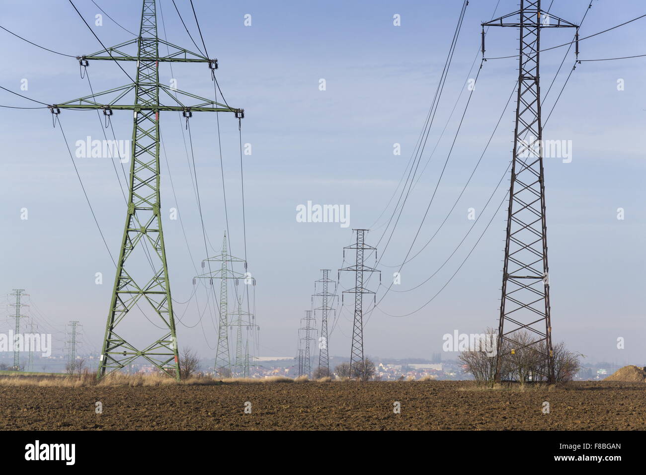 Electricity pylons leading from distribution power station blue cloudy ...