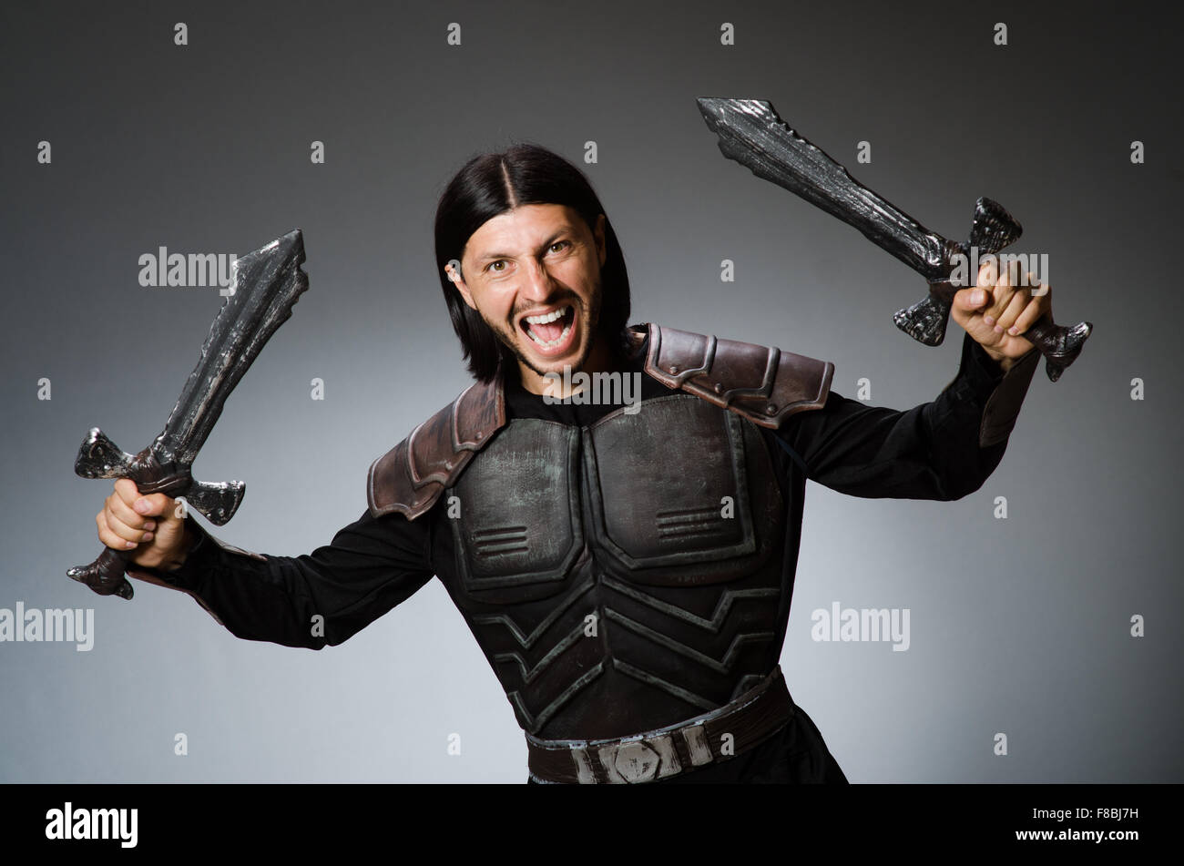 Angry knight with sword against dark background Stock Photo - Alamy