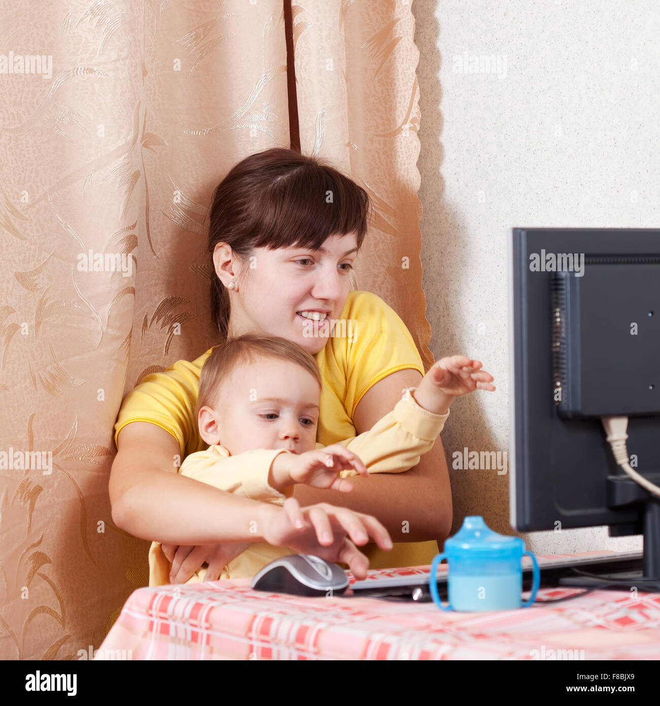 Woman with baby working with computer at home Stock Photo - Alamy
