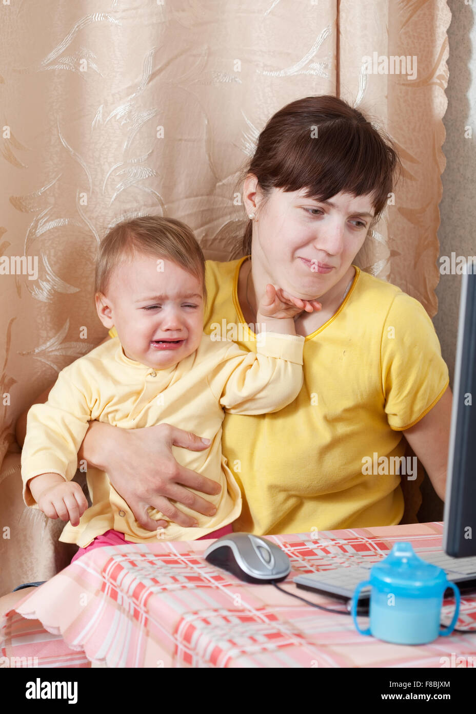 mother with crying baby working with computer Stock Photo - Alamy