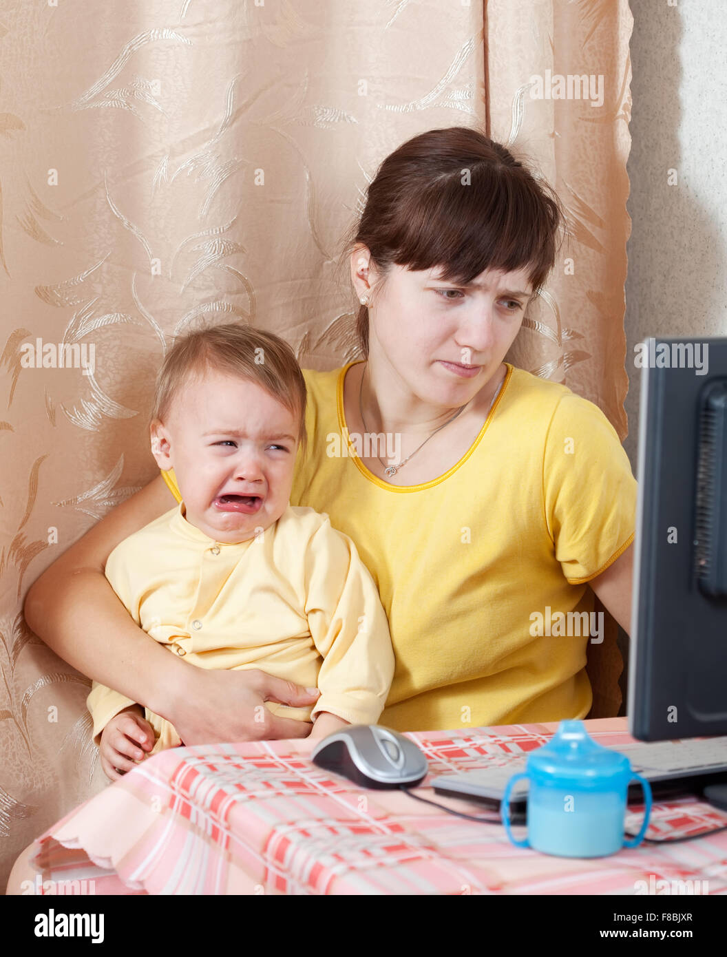 mother with crying baby working with computer Stock Photo - Alamy
