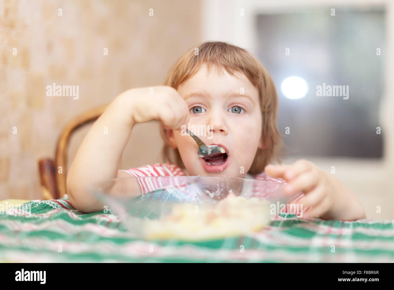 child eats potato with spoon in home Stock Photo - Alamy