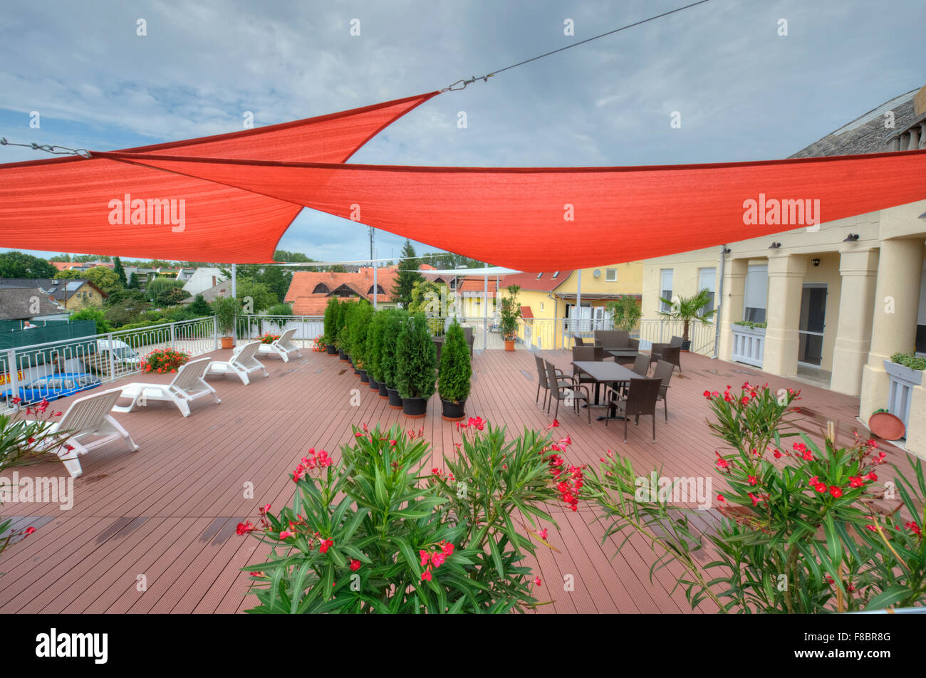 Terrace in summer with shade sails, flowers and deck chairs Stock Photo ...