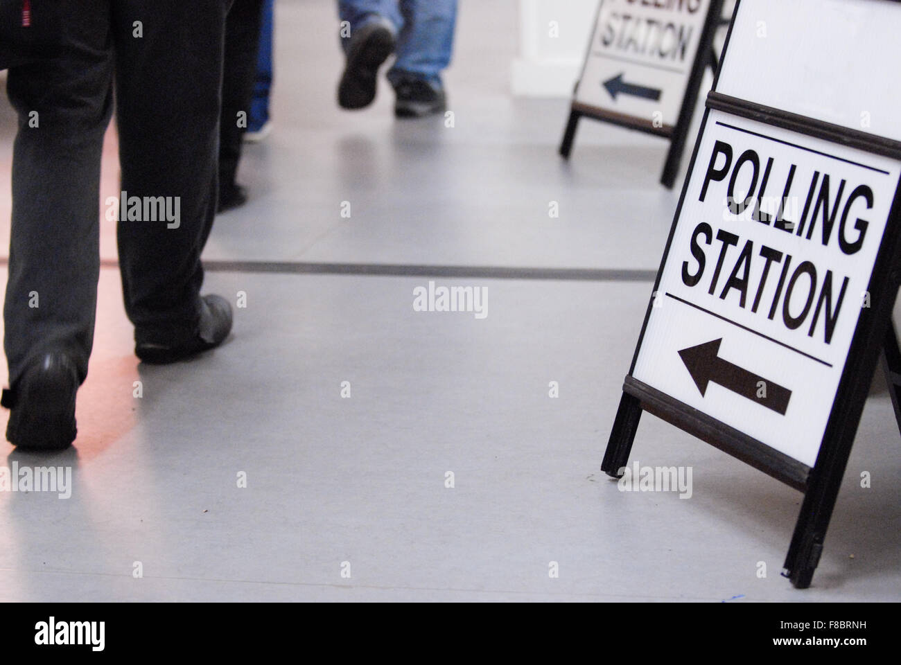 People walk past a polling station sign with arrow in Aberdeen ...