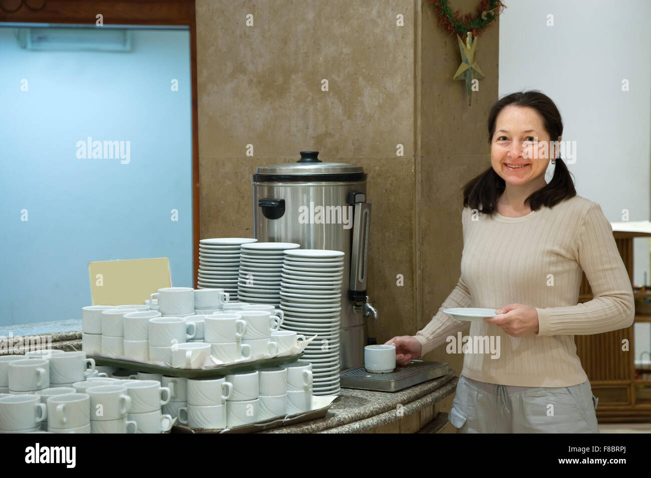Woman pours tea from electric water boiler Stock Photo - Alamy