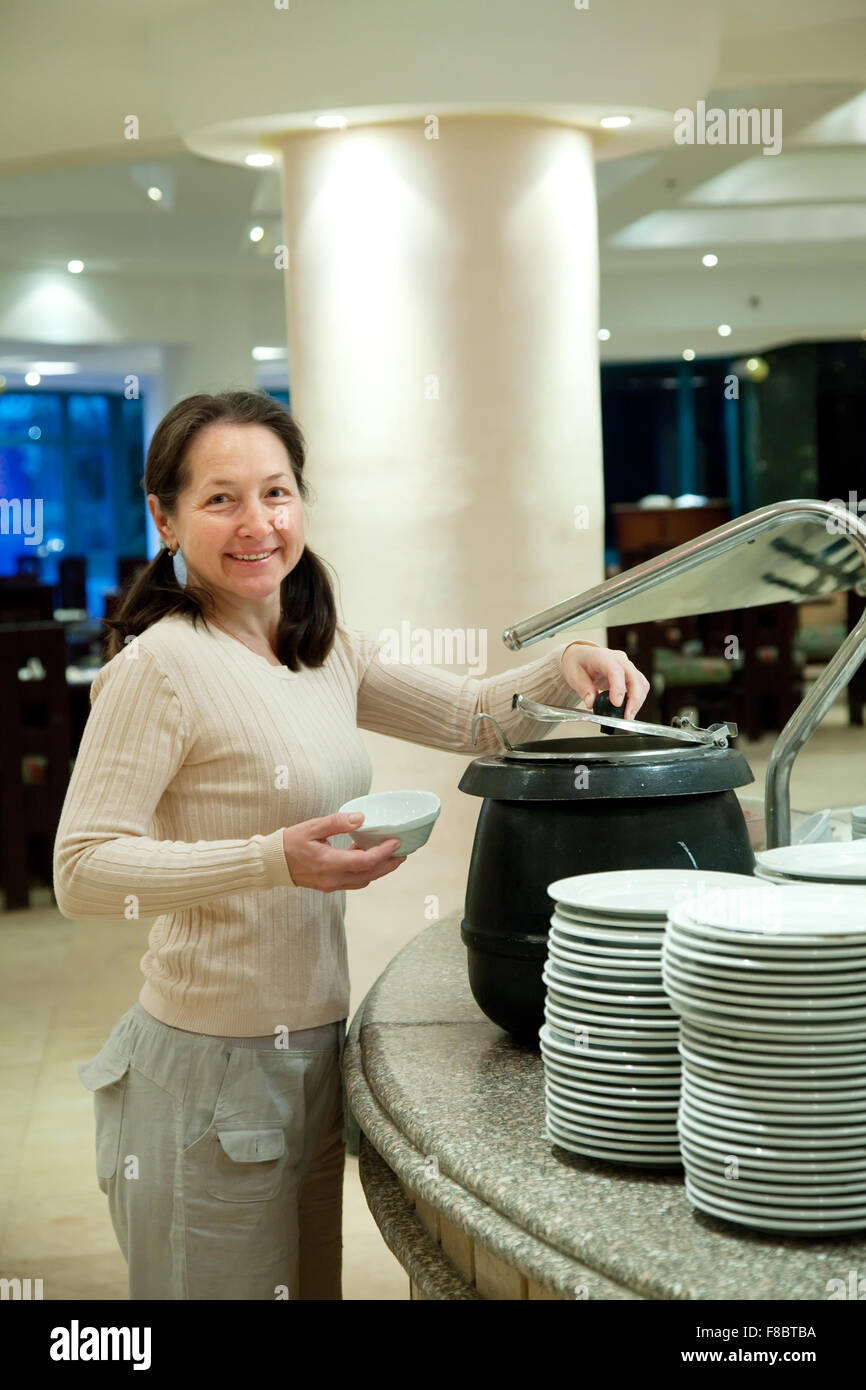 Female pour the soup on the buffet table Stock Photo - Alamy
