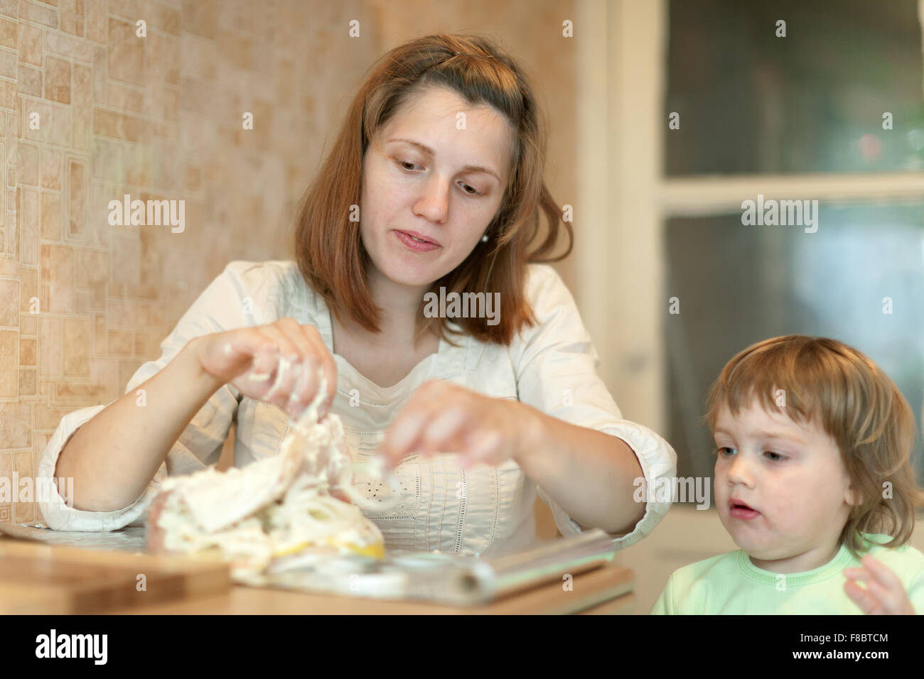 Woman with child cooking in the kitchen together Stock Photo - Alamy