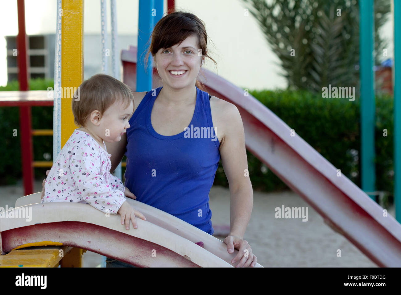 happy mother with toddler on slide playground area Stock Photo - Alamy