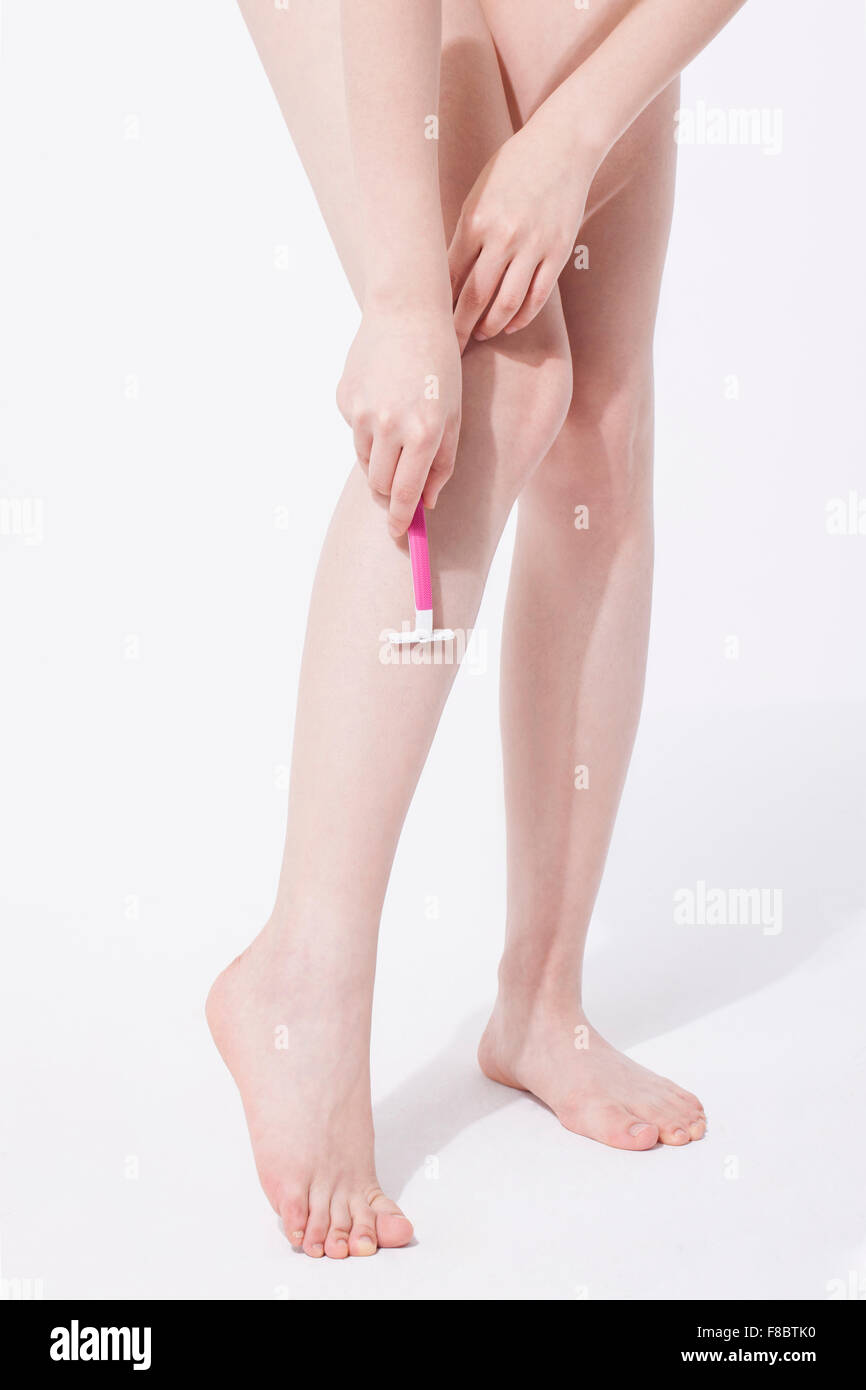 Legs of woman standing and shaved with a razor Stock Photo - Alamy