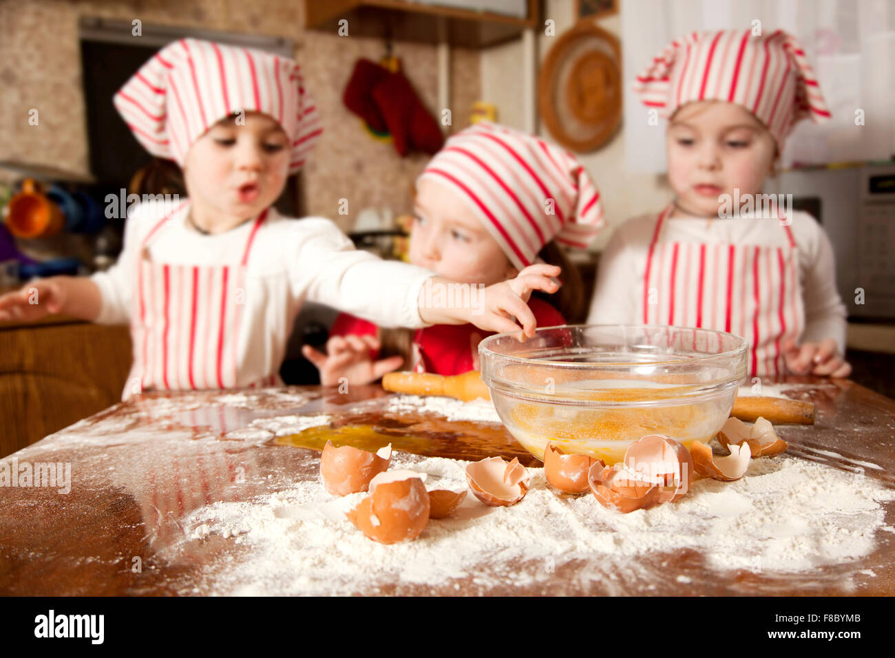Three little chefs enjoying in the kitchen making big mess. Litt Stock ...