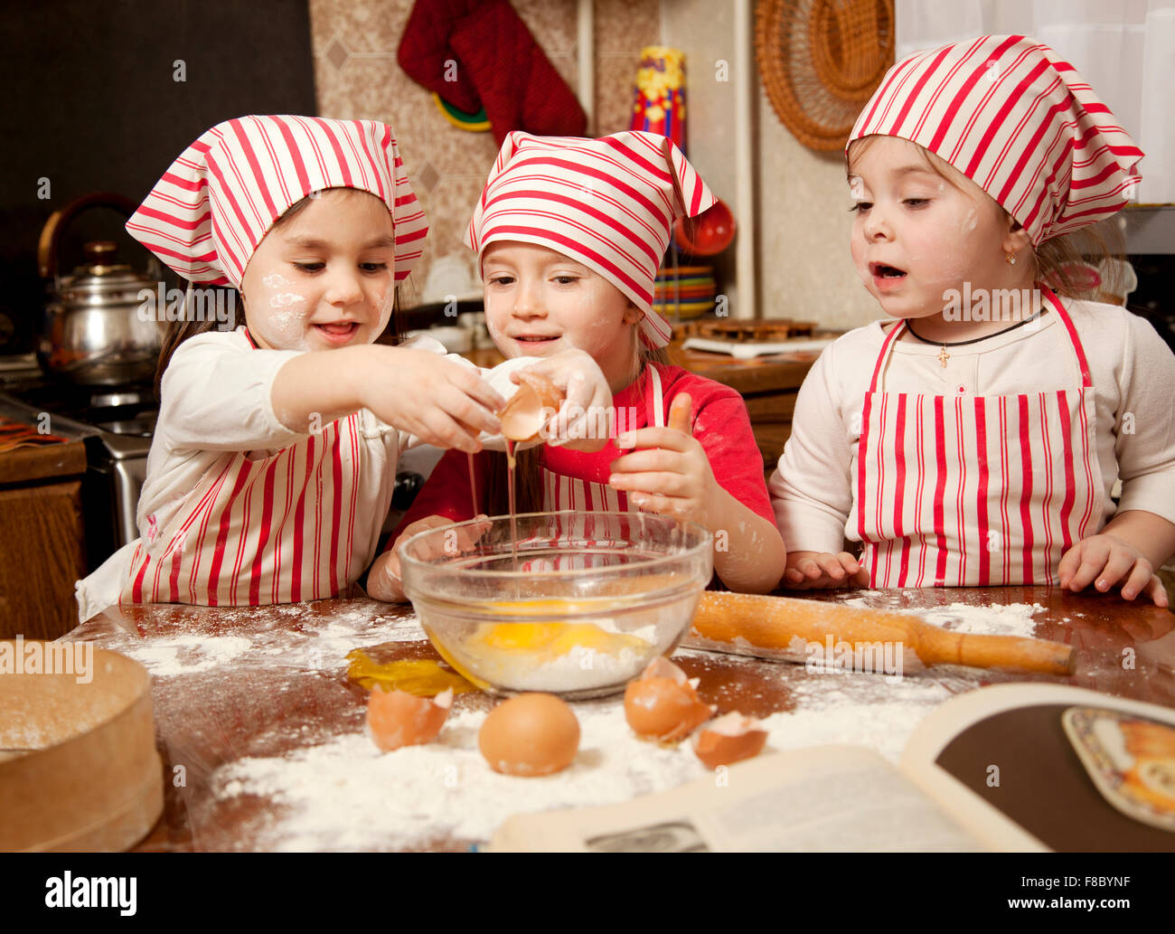 Three little chefs enjoying in the kitchen making big mess. Litt Stock ...