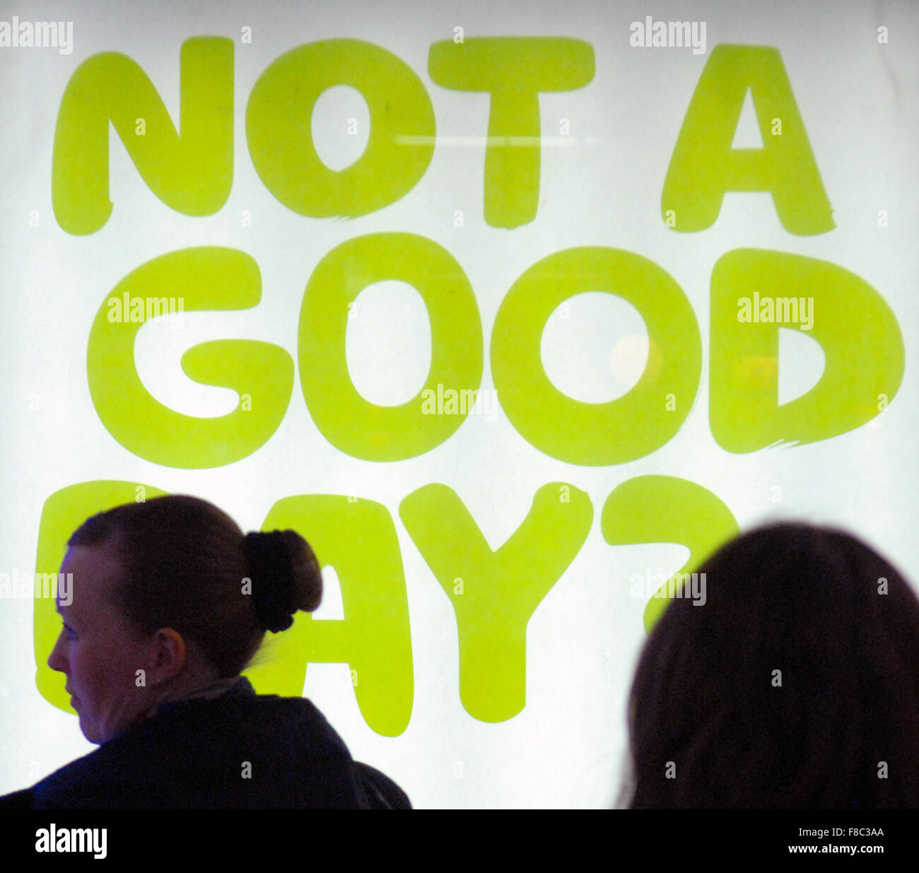 Two women walk past a sign reading 'Not a good day' in Aberdeen Airport ...