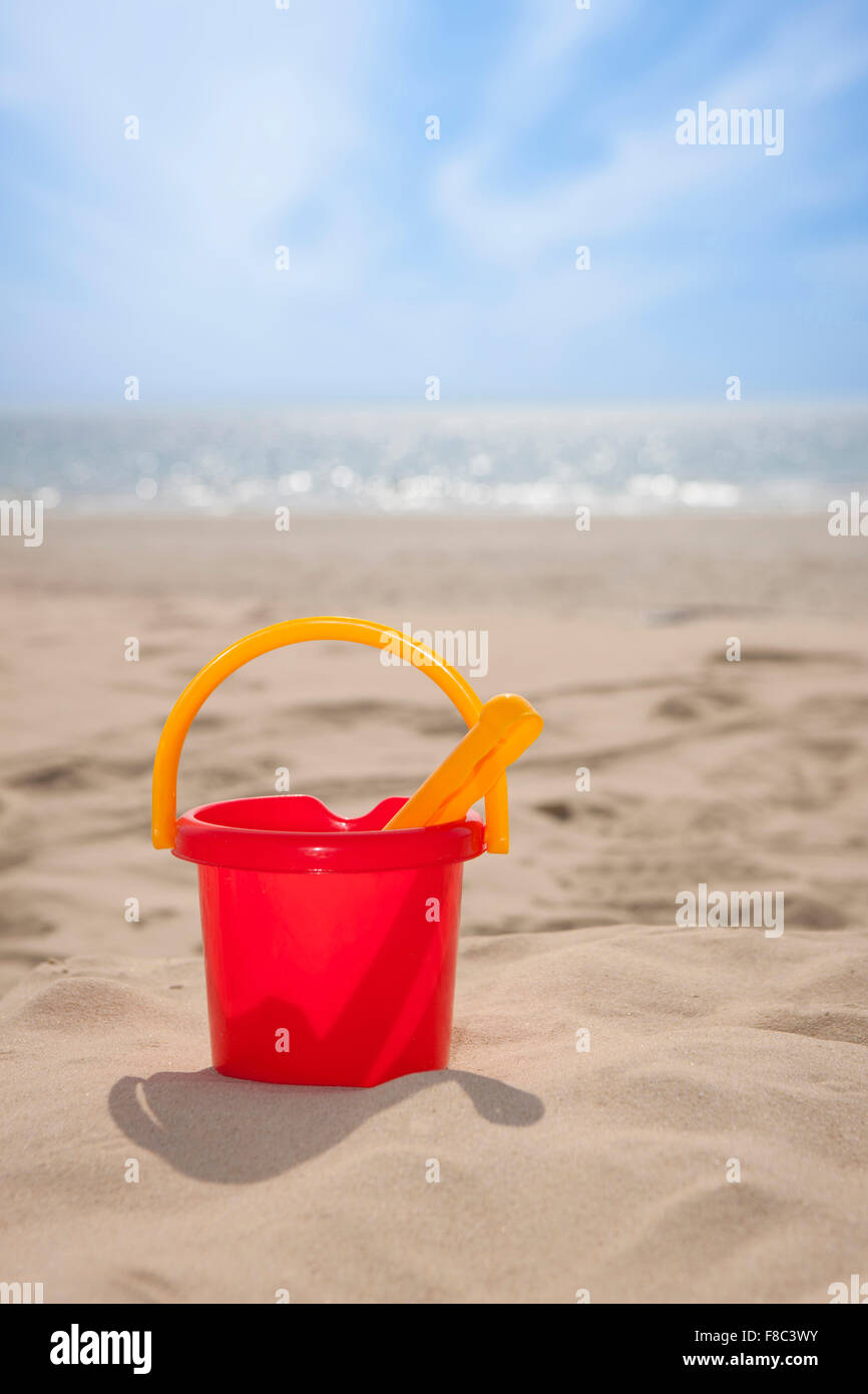 Plastic bucket on sand in out-focused effect with the background of ...