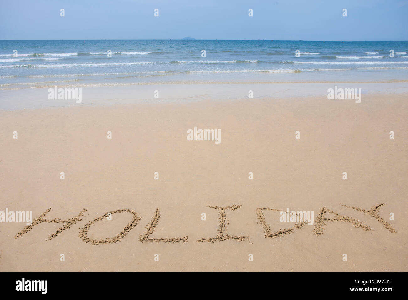 Word HOLIDAY written on sand at beach Stock Photo - Alamy