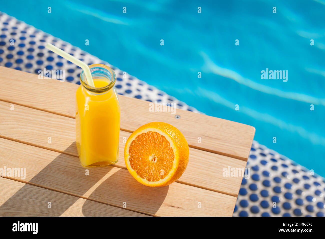 Bottle of orange juice with straw and orange showing the cross section ...