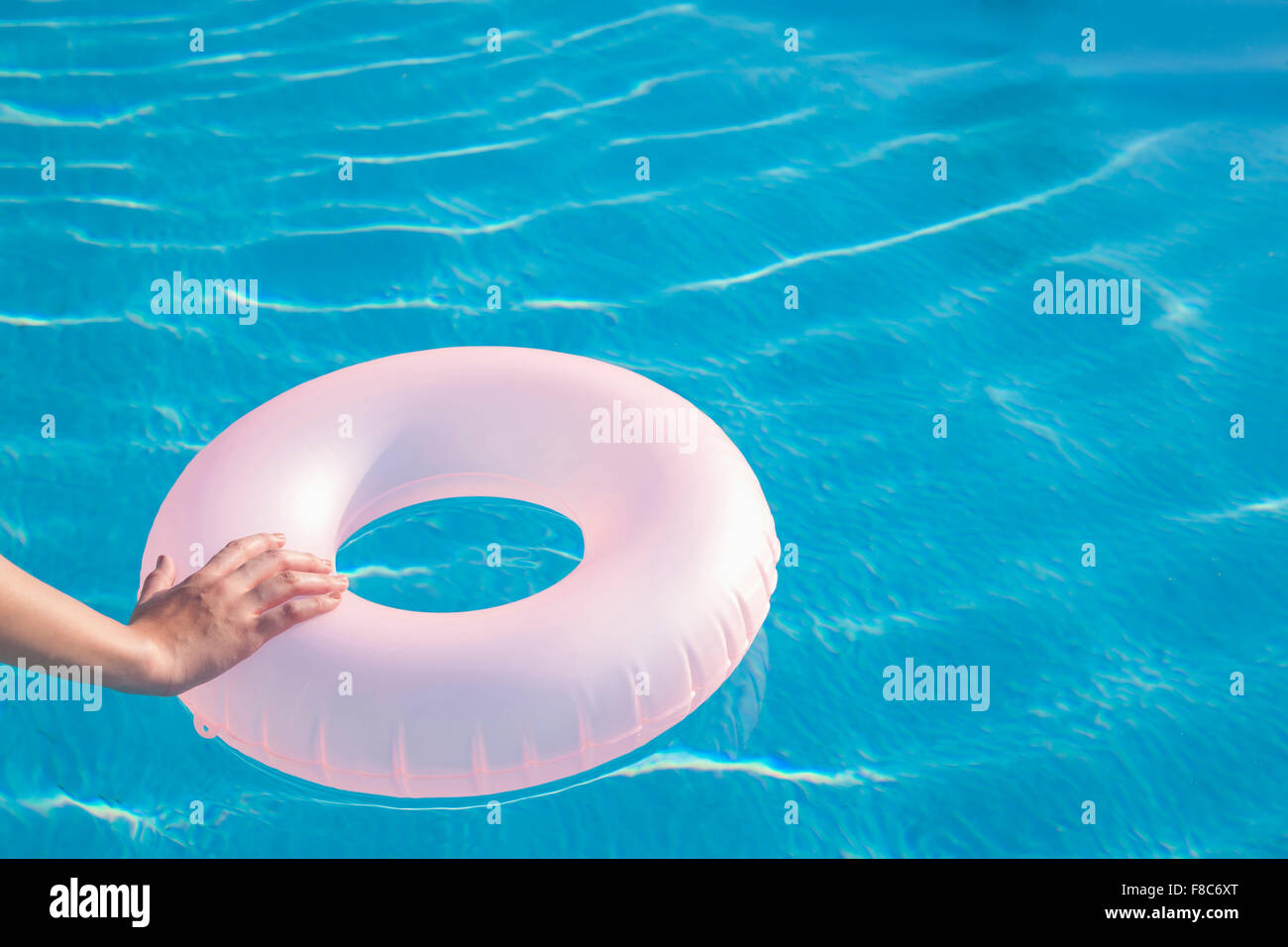 Hand on pink inflatable round tube floating in swimming pool Stock ...