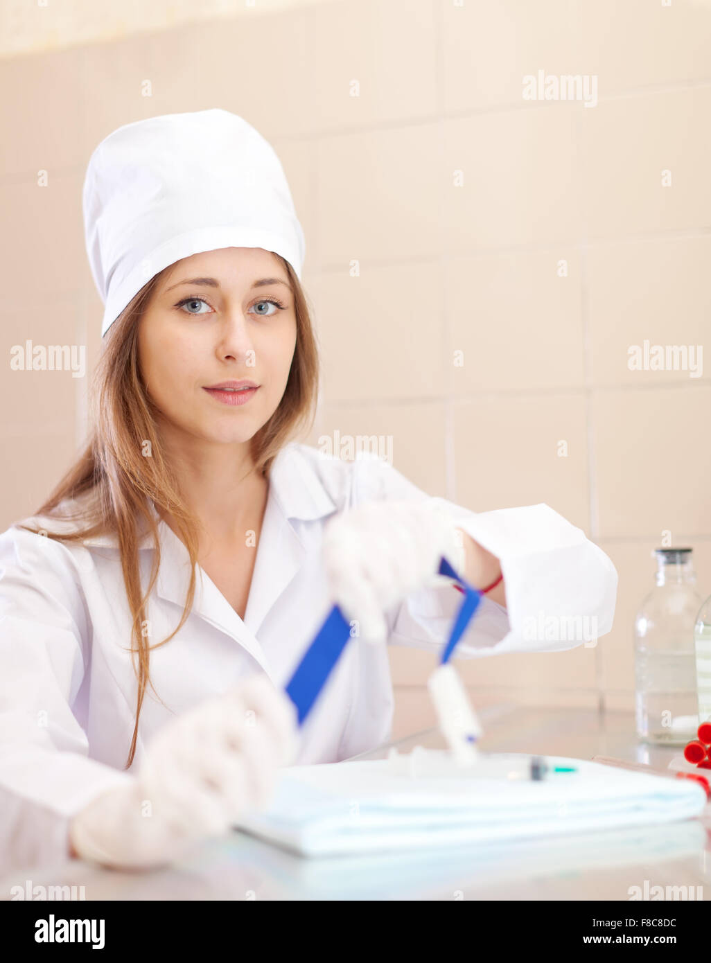 Positive young nurse with tourniquet in medical laboratory Stock Photo ...