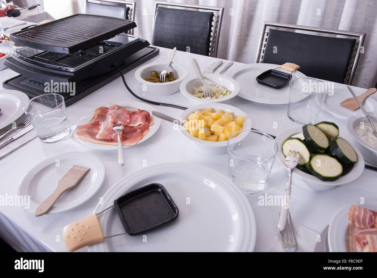 dinner table prepared for raclette with friends Stock Photo - Alamy
