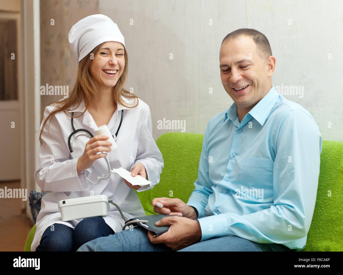 Happy nurse gives to patient the medication in home Stock Photo - Alamy