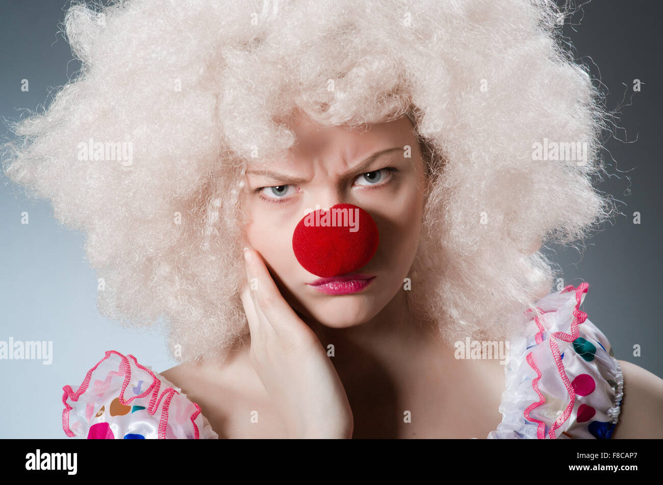 Clown with white wig against grey background Stock Photo - Alamy