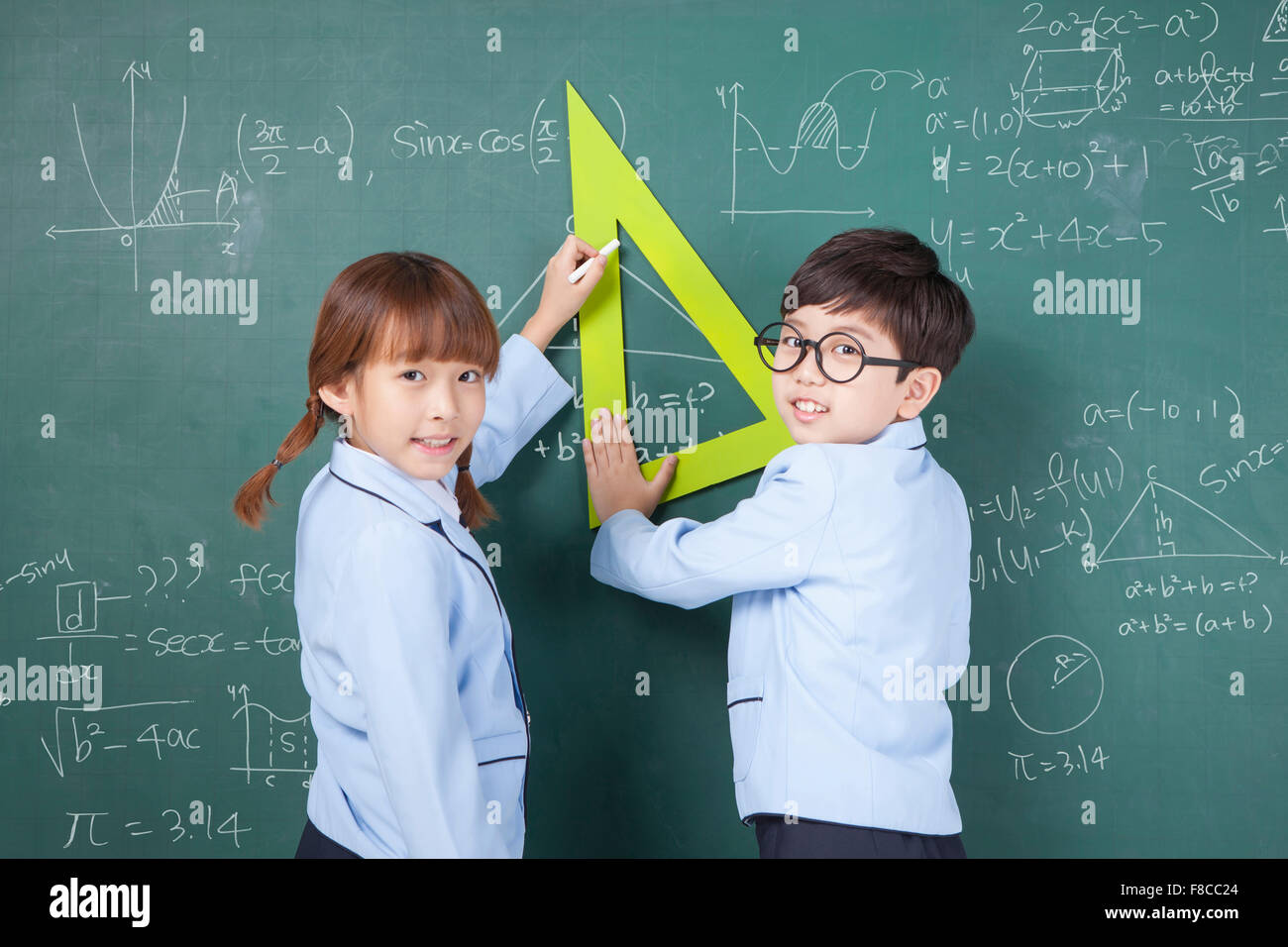 Elementary school age boy and girl holding a triangular shape object ...