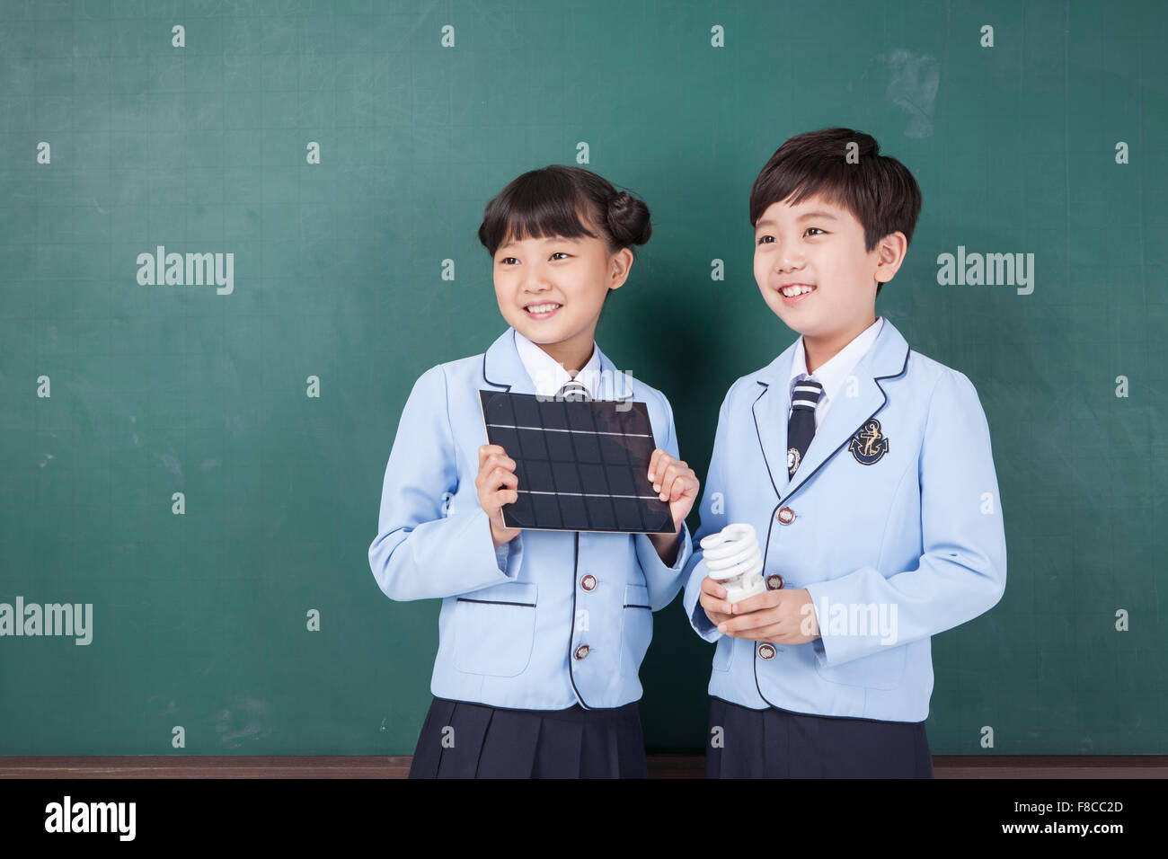 Elementary school age boy and girl holding science related objects and ...