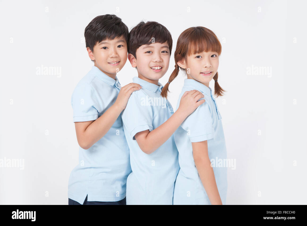Two boys and a girl in school uniforms together staring forward all in ...