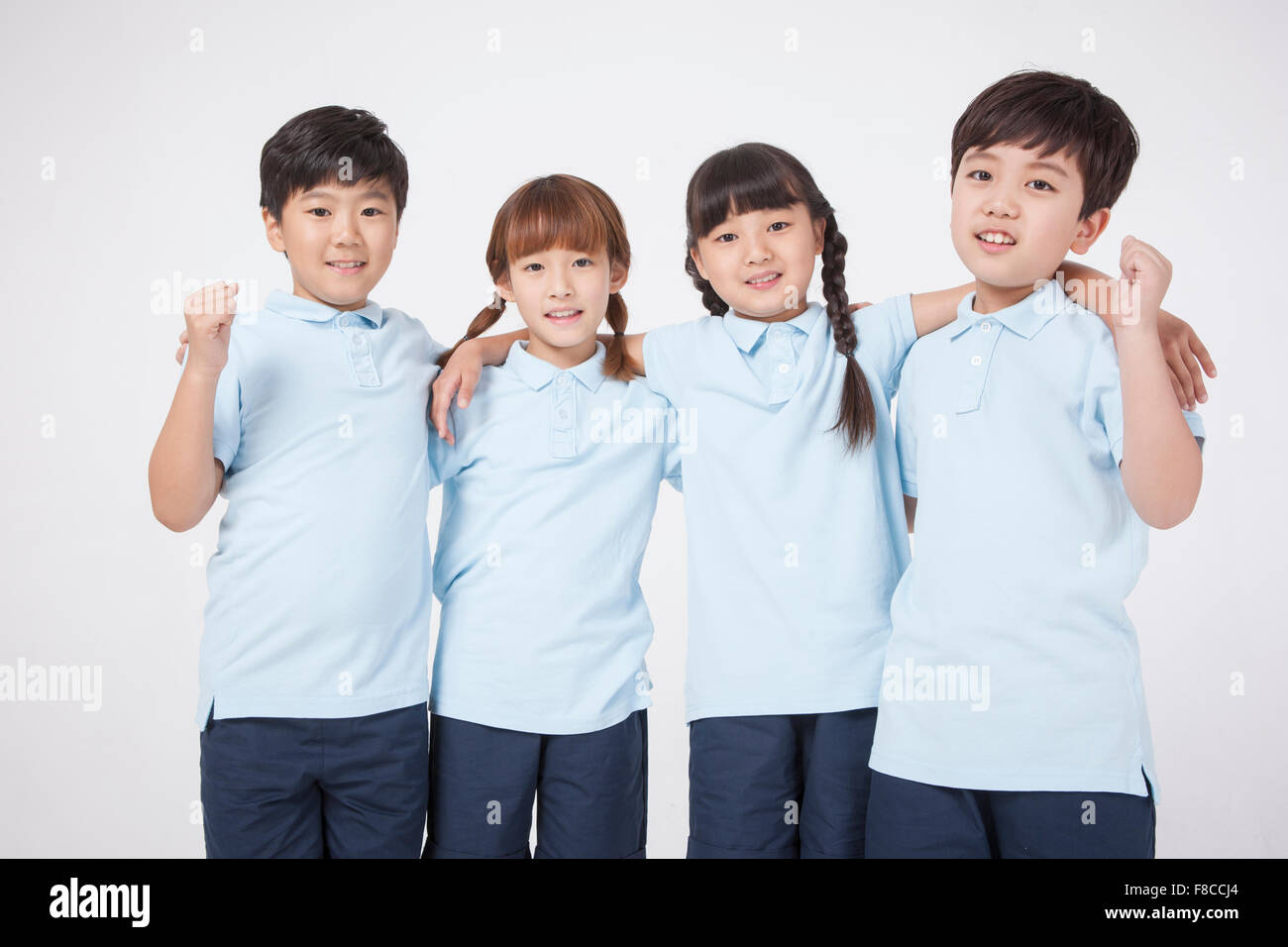 Four elementary school students in sports uniform with their arms ...