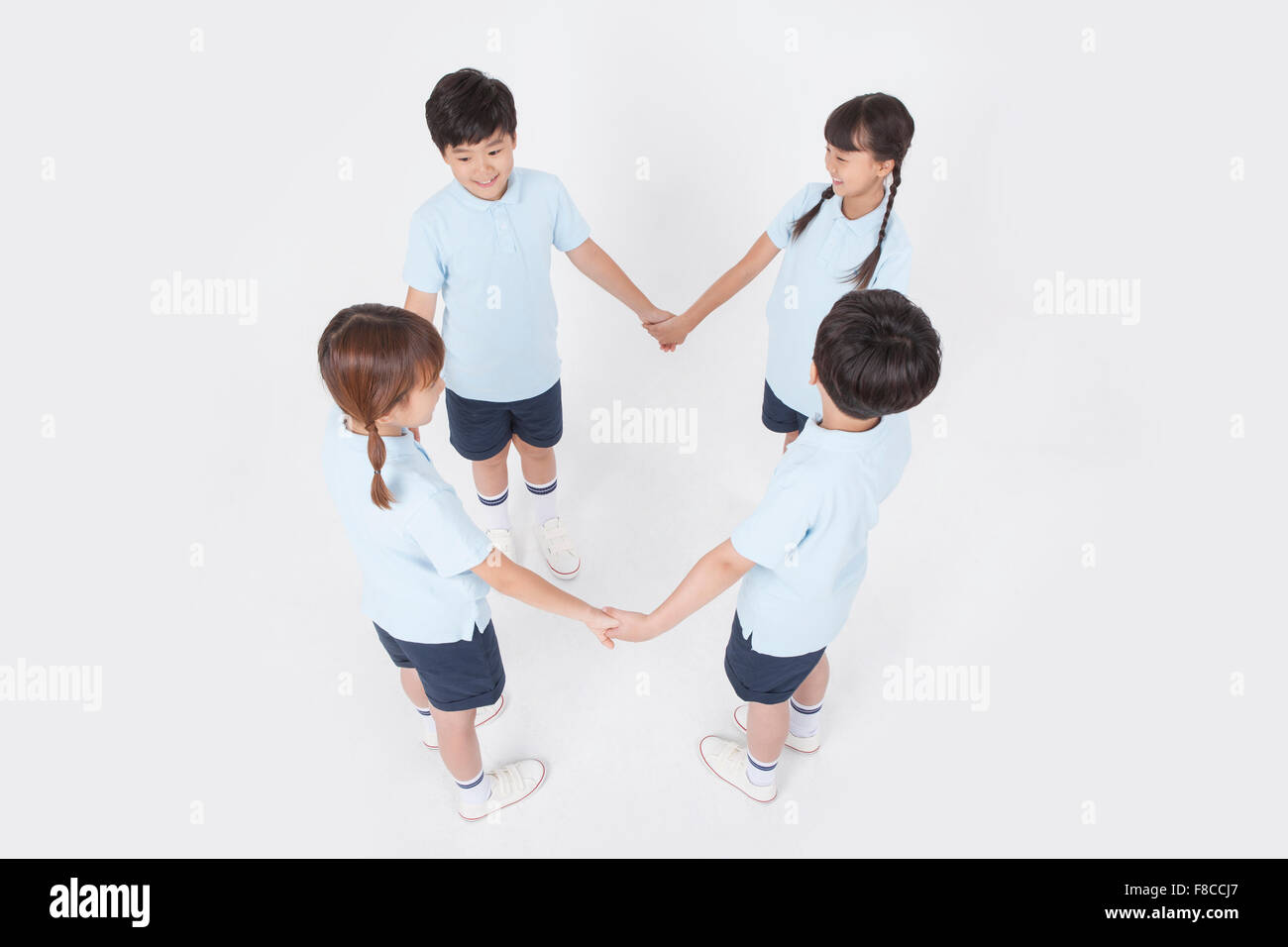 High angle of four elementary school students in sports uniforms ...