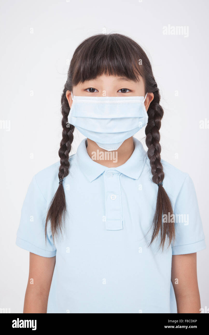Elementary school girl in sports uniforms wearing a mask and staring ...
