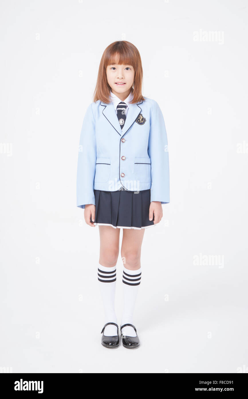 Elementary school girl in school uniforms with short hair standing with ...