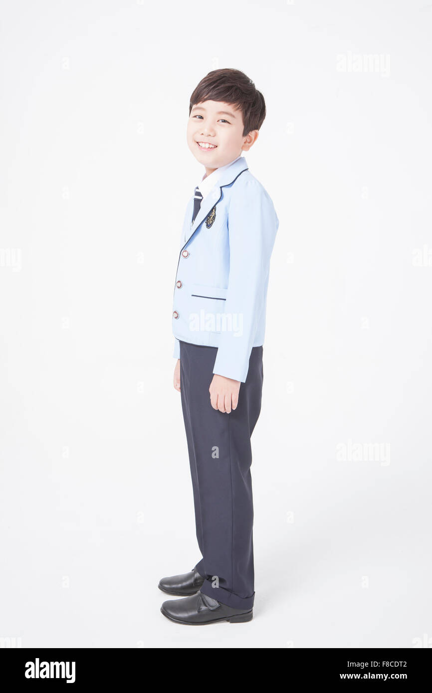 Elementary school boy in school uniforms standing sideways and staring ...